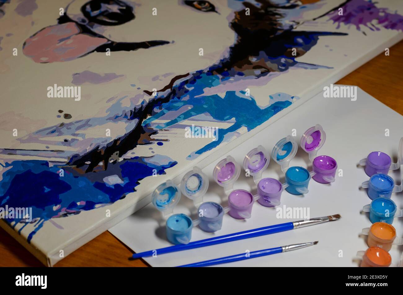 Colorful picture of husky dog on canvas, paint cans and brushes ...