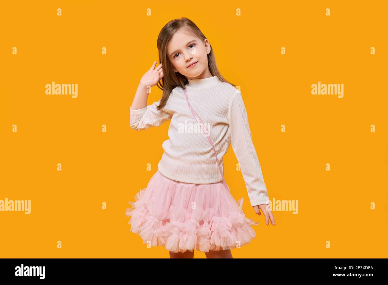 Cute little child posing on bright yellow background Stock Photo - Alamy