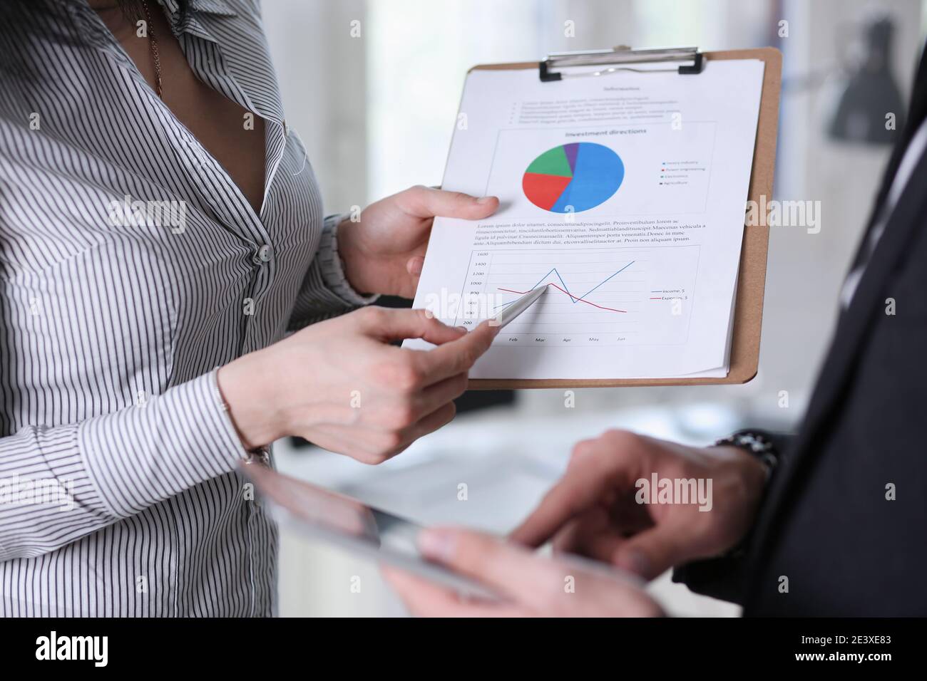 Group of people deliberate on problem with clipboard Stock Photo - Alamy