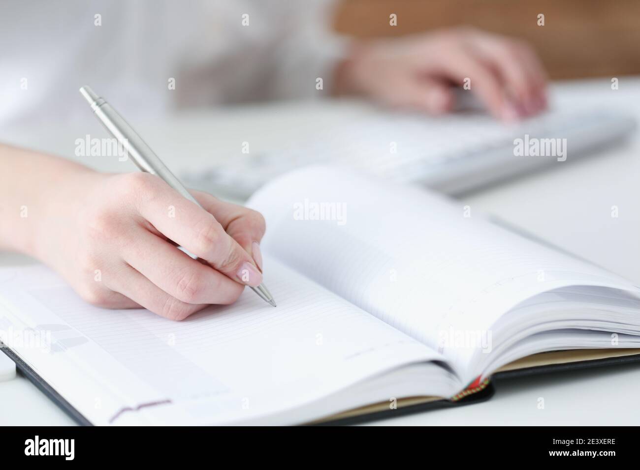 Female hand holding silver pen ready to make note Stock Photo - Alamy