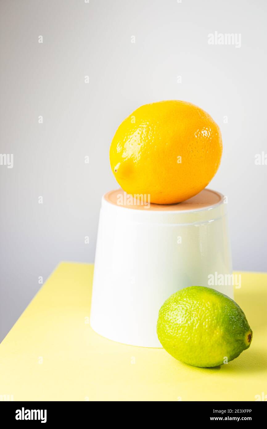 Fresh lemon and lime over two tone background, yellow and white ...