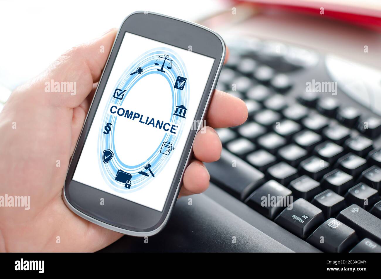 Hand holding a smartphone showing a compliance concept Stock Photo - Alamy