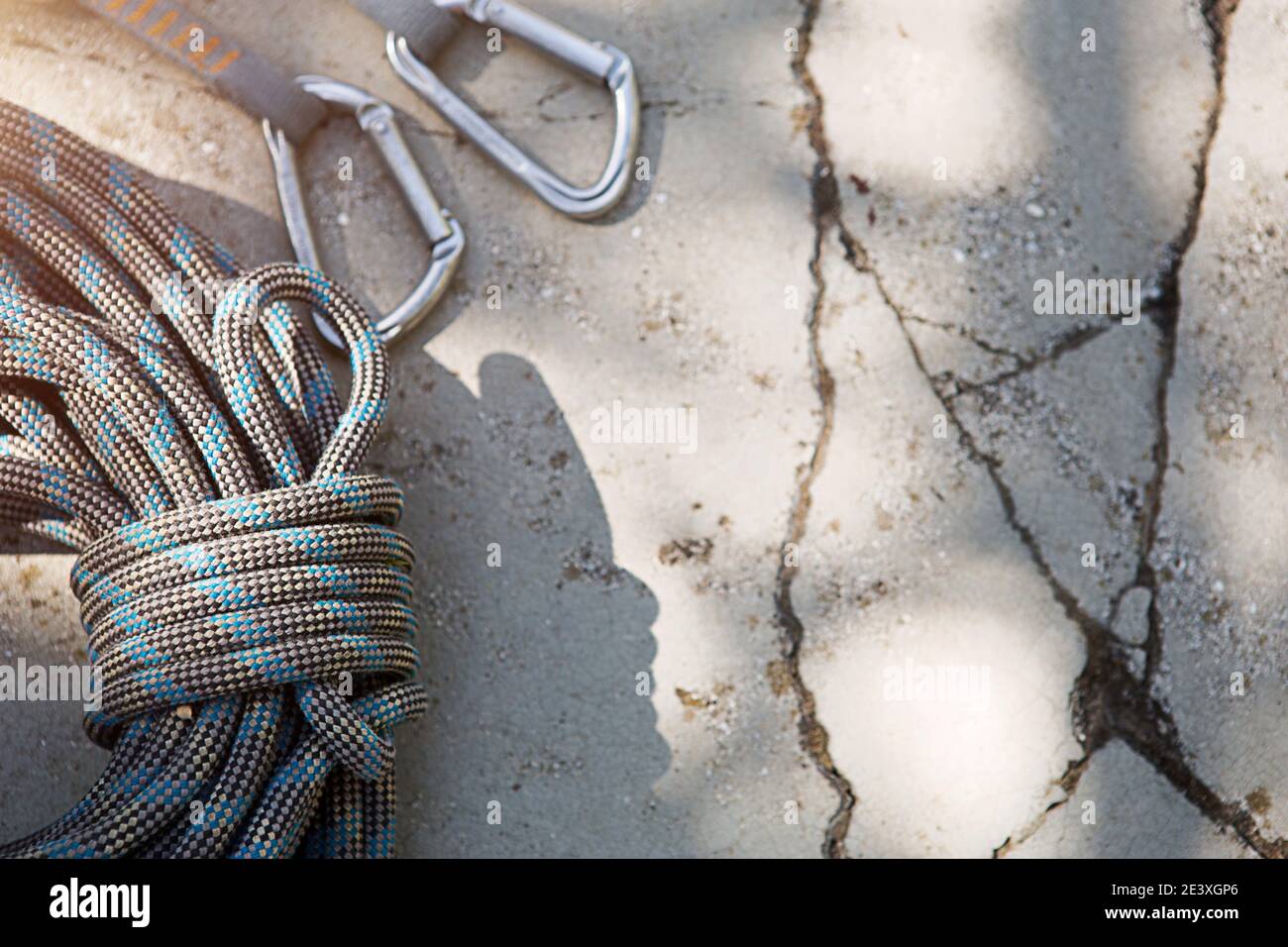 Coiled climbing rope and steel carabiner. Mountain climbing equipment ...