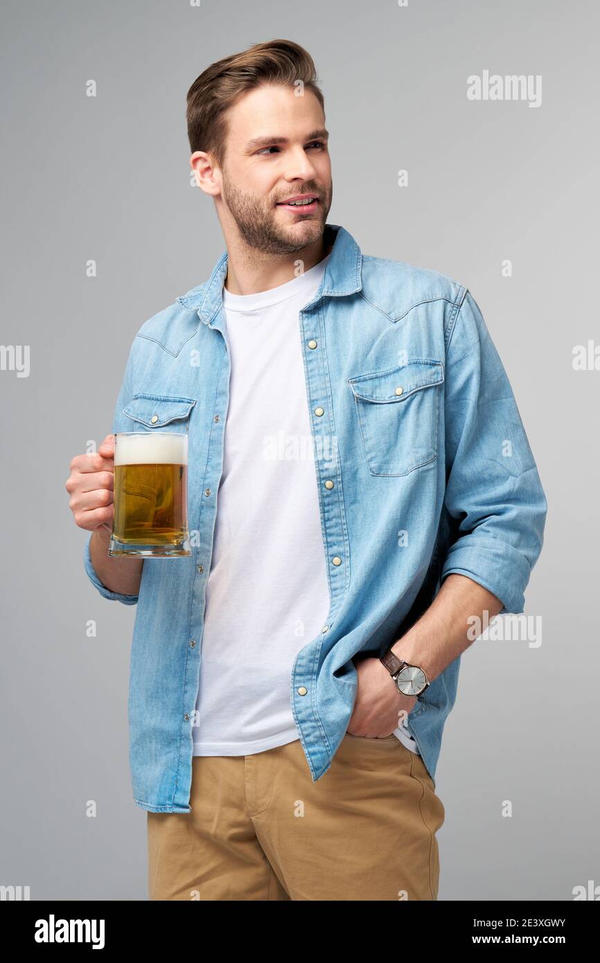 Young Man holding wearing jeans shirt holding glass of beer standing ...