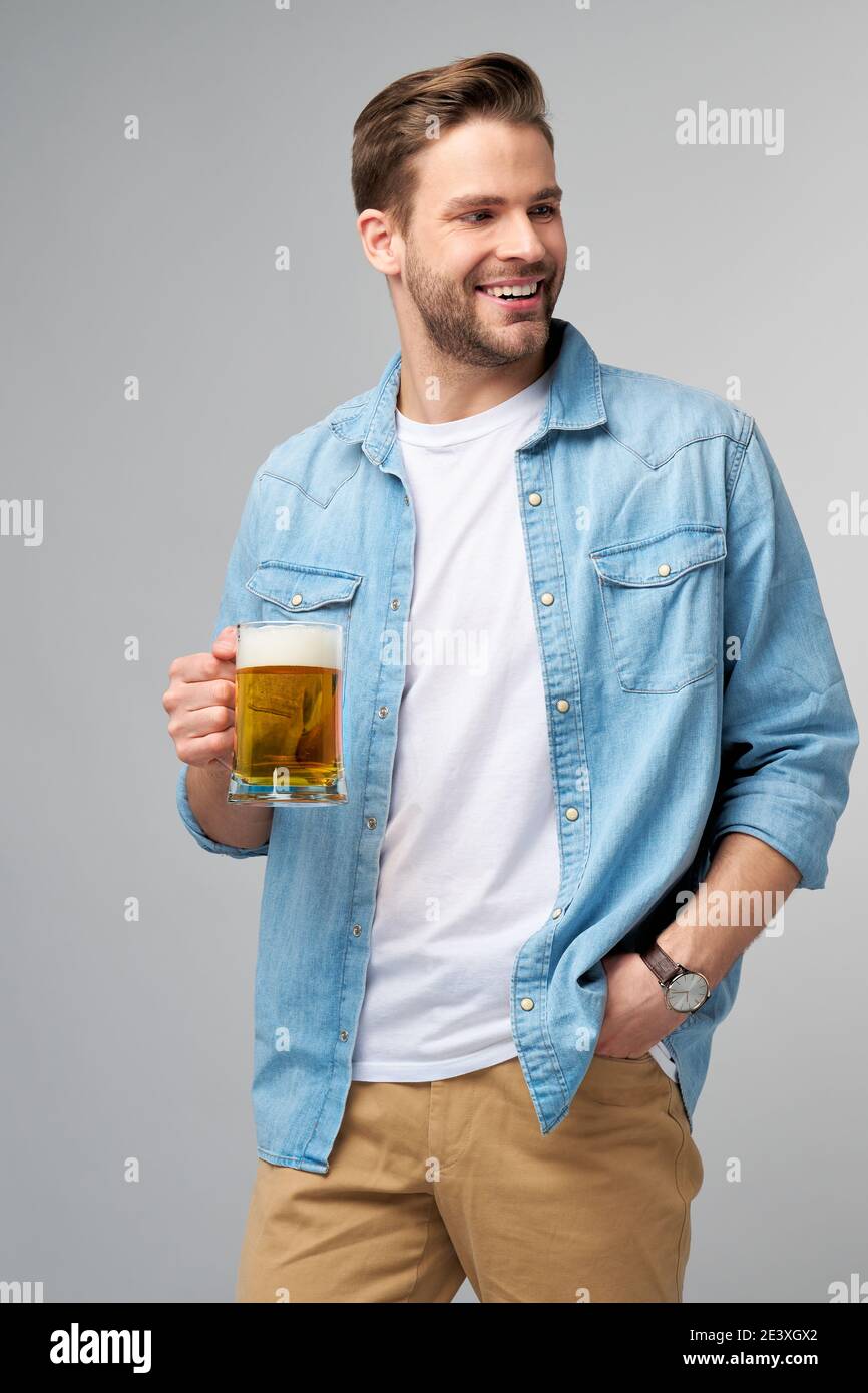Young Man holding wearing jeans shirt holding glass of beer standing ...
