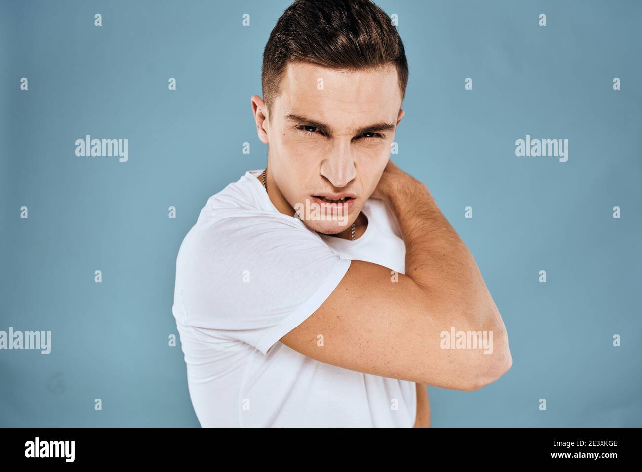 emotional displeased man cropped view white t-shirt blue background ...