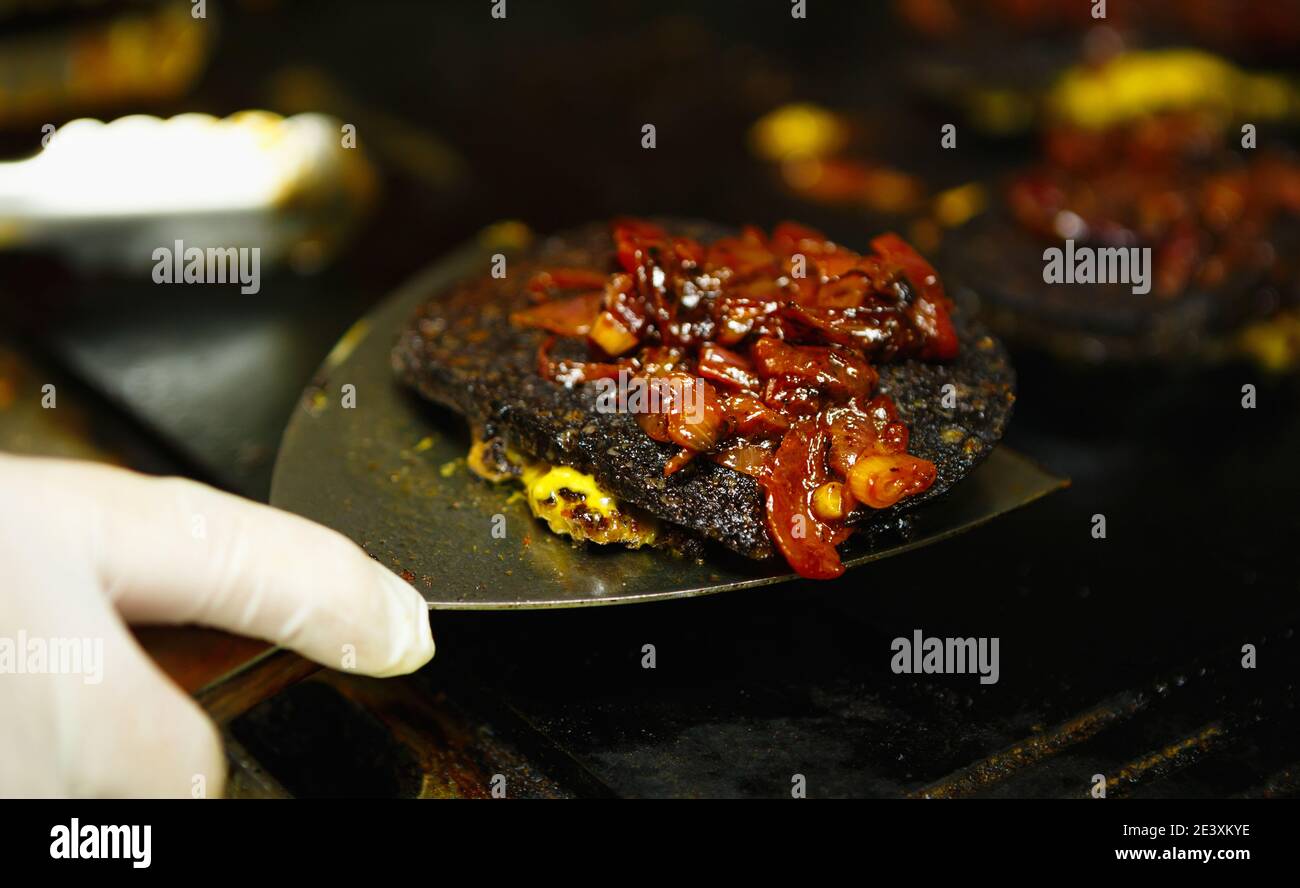 Black pudding steak frying on hot pan in fast food restaurant.Chef ...
