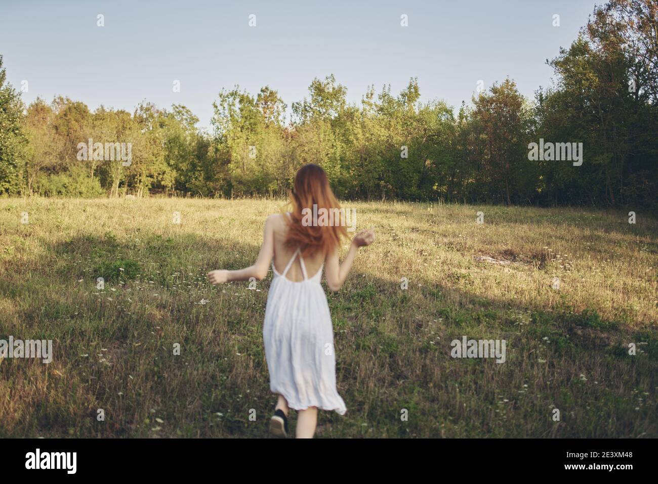 happy journey in a white sundress running on the grass in nature Stock ...