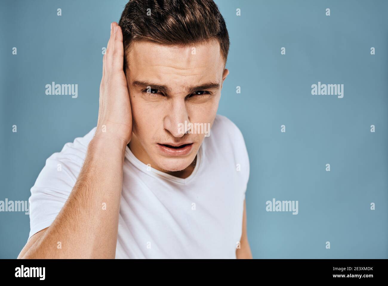 emotional displeased man cropped view white t-shirt blue background ...