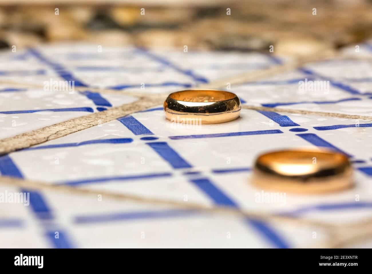 wedding ceremony rings laid on top of tiles with decorative pattern ...
