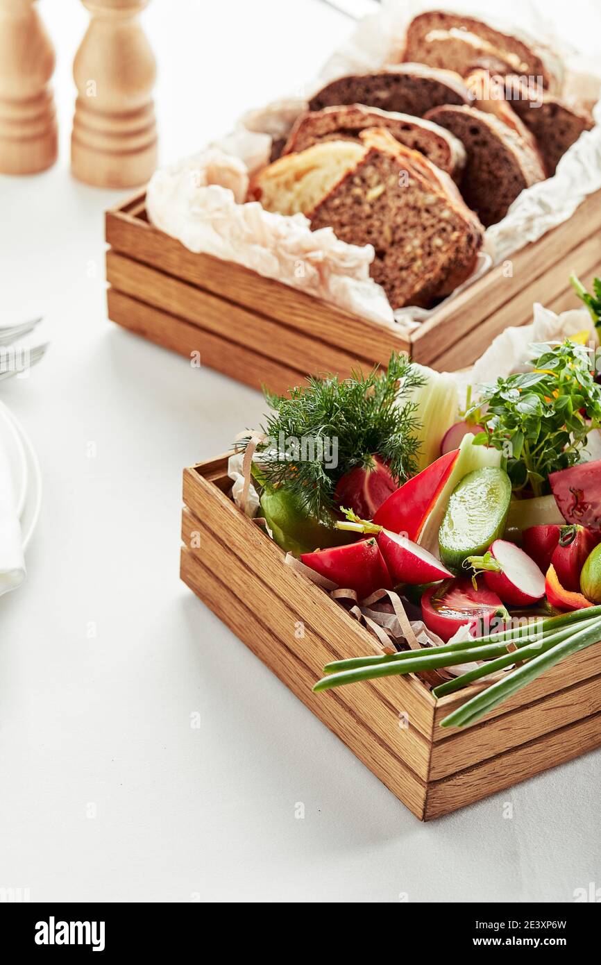 chopped fresh vegetables in a wooden box on a white background. Banquet ...