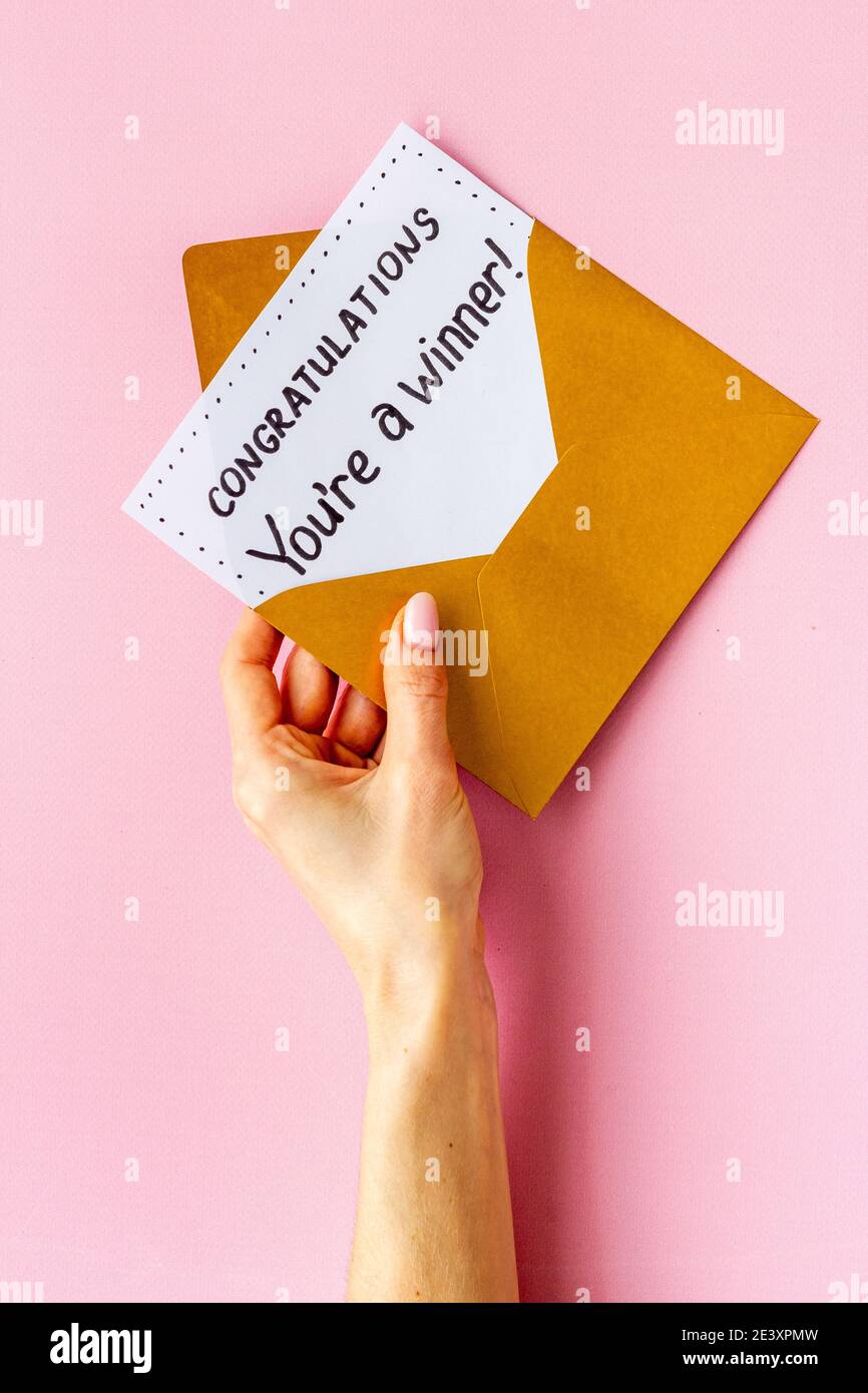 Female hand holds envelope with card You are a winner. Congratulations ...