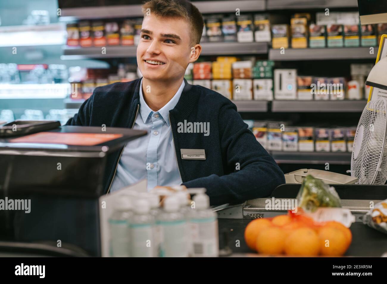 Man working at cash counter of a supermarket. Teenage cashier working ...