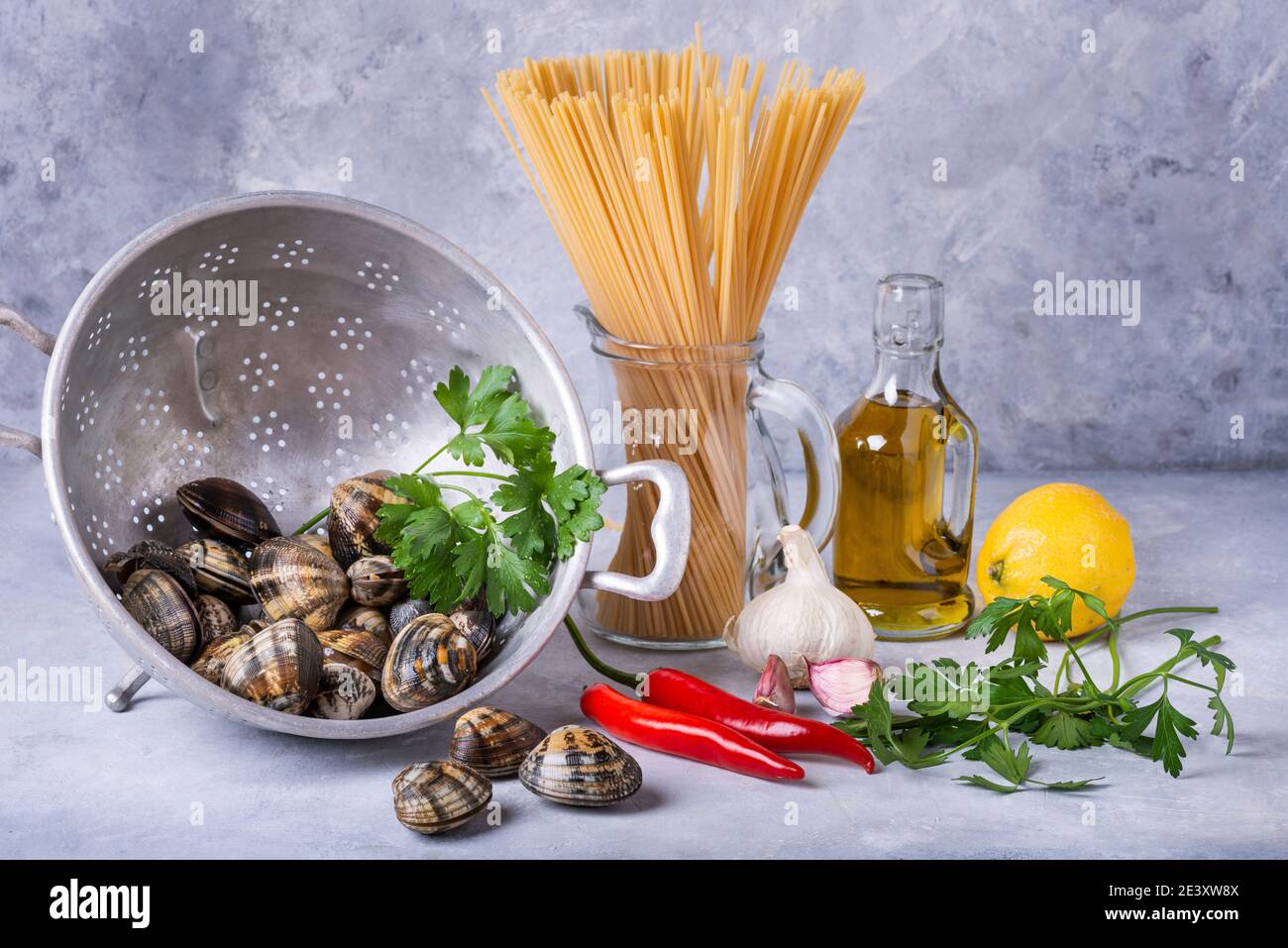 on a gray structure background, in an old colander, fresh clams with ...