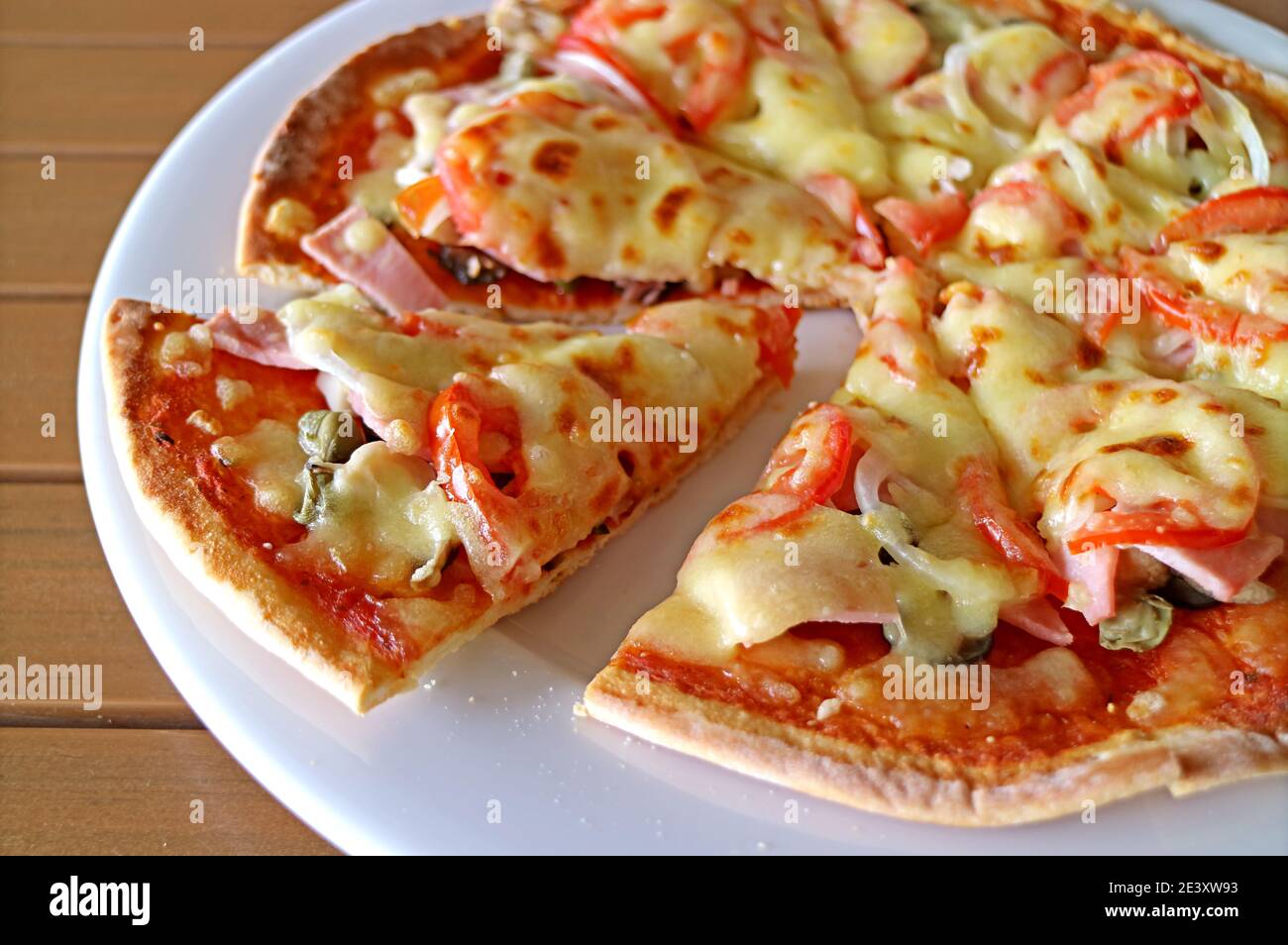 Delectable Crispy Cheesy Ham and Tomato Pizza on a White Plate Stock ...
