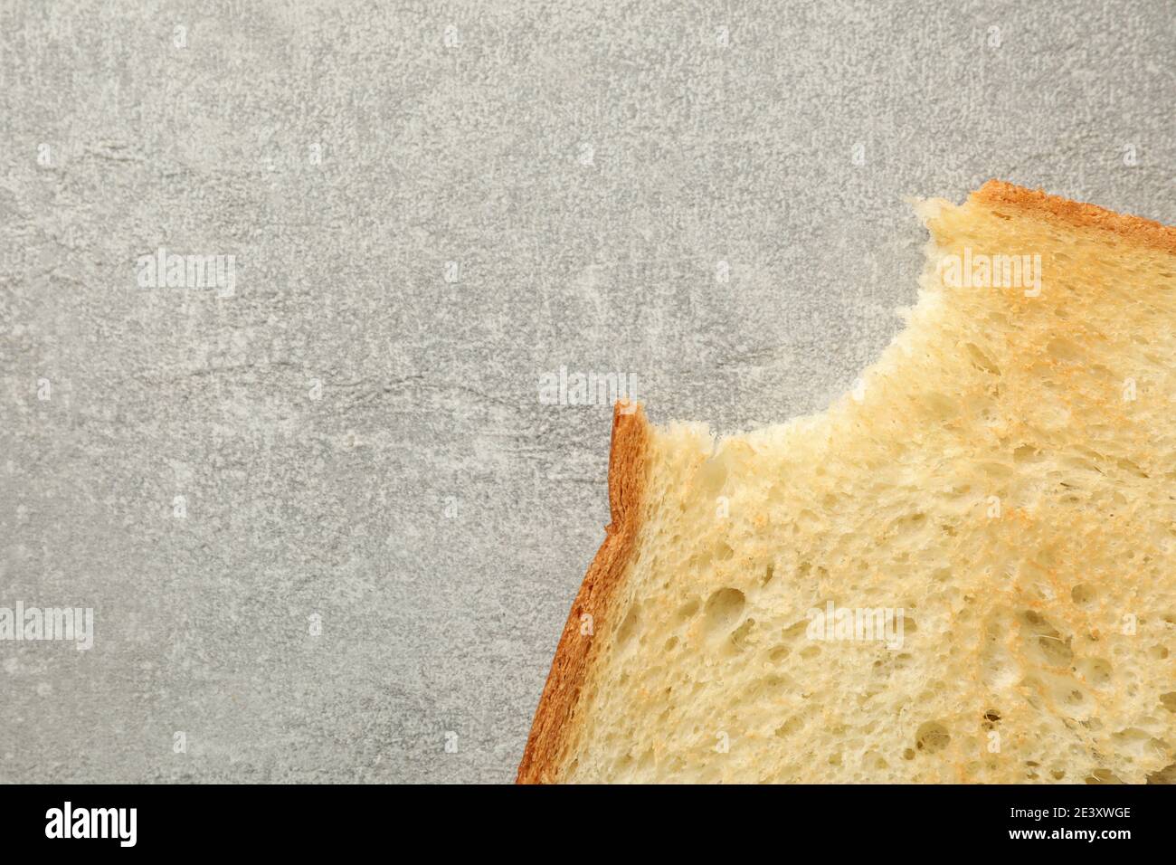 Bitten toast bread on gray background, space for text Stock Photo - Alamy