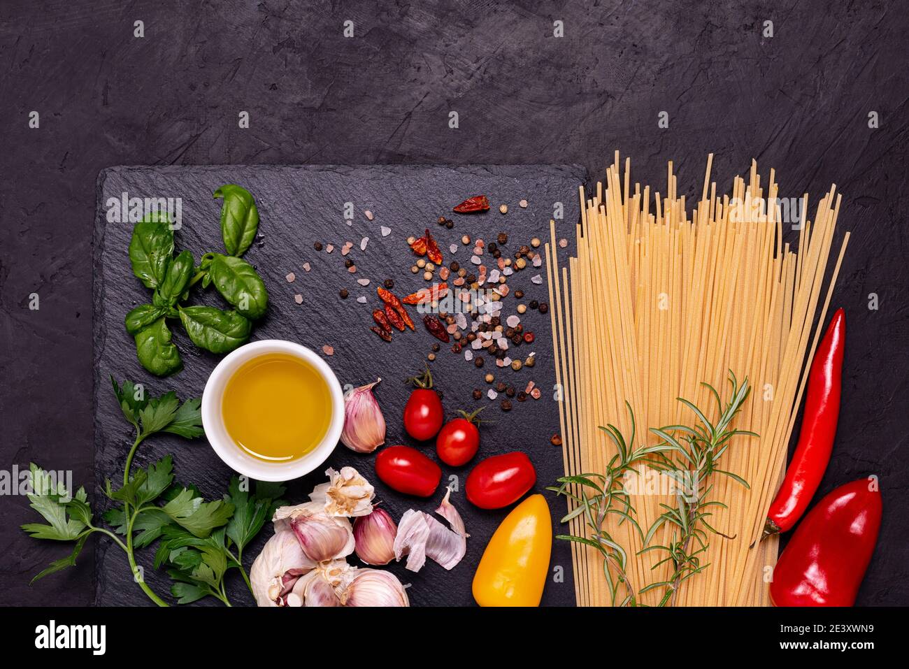 Italian food: on a slate stone, raw spaghetti, garlic, olive oil and ...