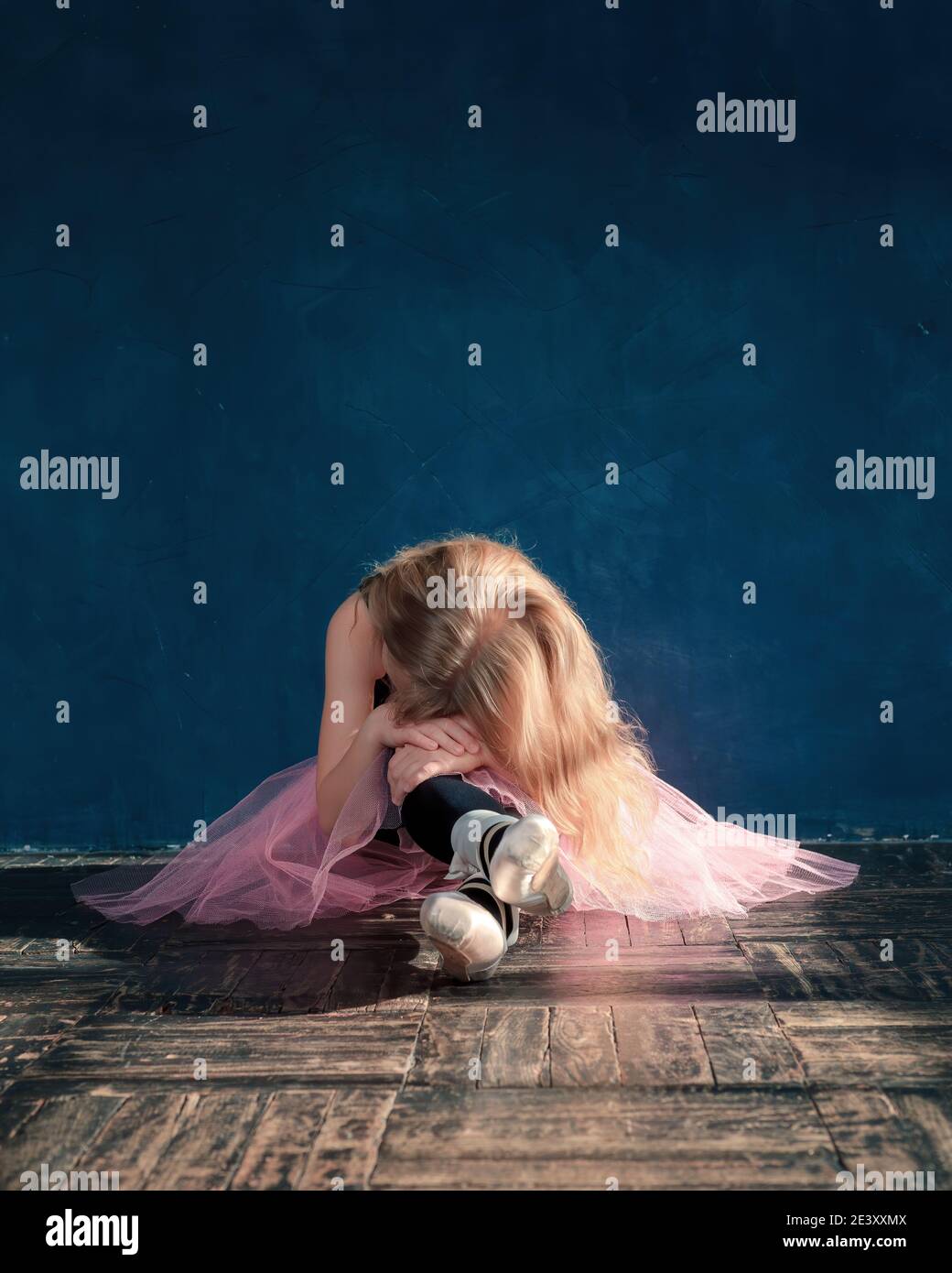 Little student girl of ballet school is crying sitting on floor because ...