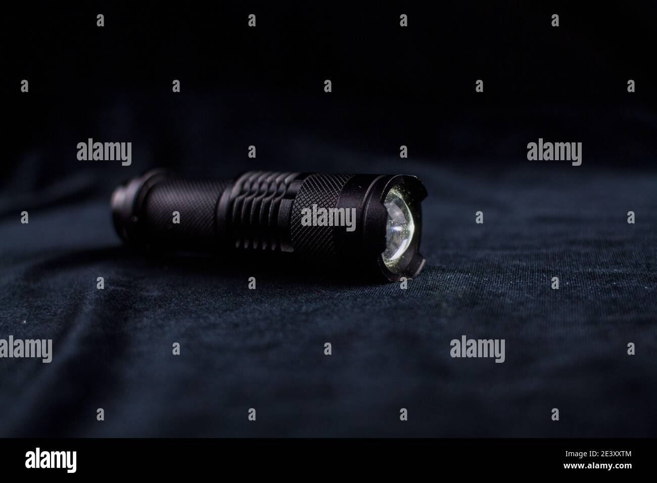 a tactical flashlight on black background shines Stock Photo - Alamy