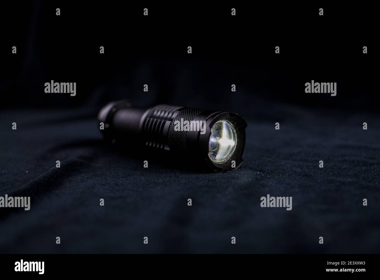 a tactical flashlight on black background shines Stock Photo - Alamy