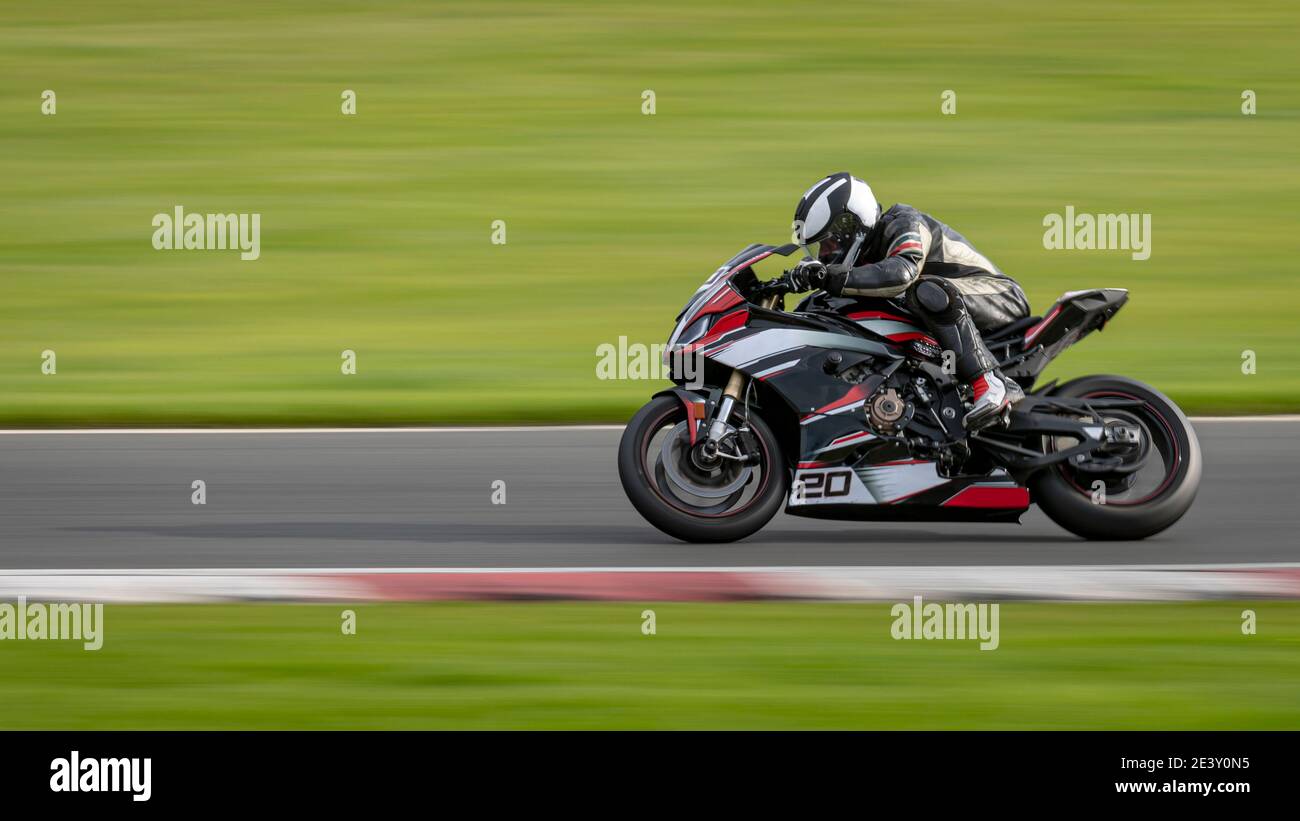 A panning shot of a racing bike cornering on a track Stock Photo - Alamy