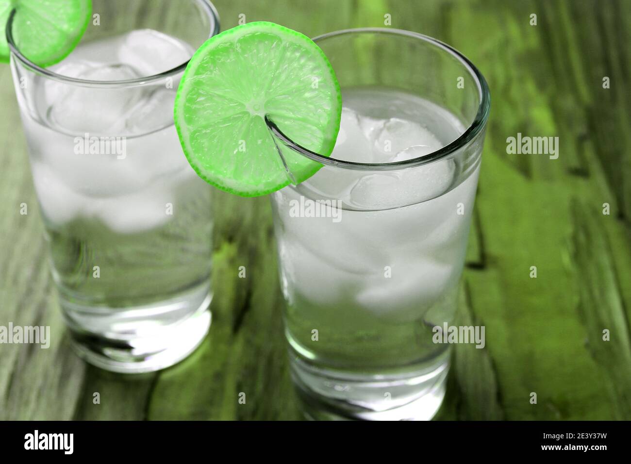 Two clear drinks with ice and lime Stock Photo - Alamy