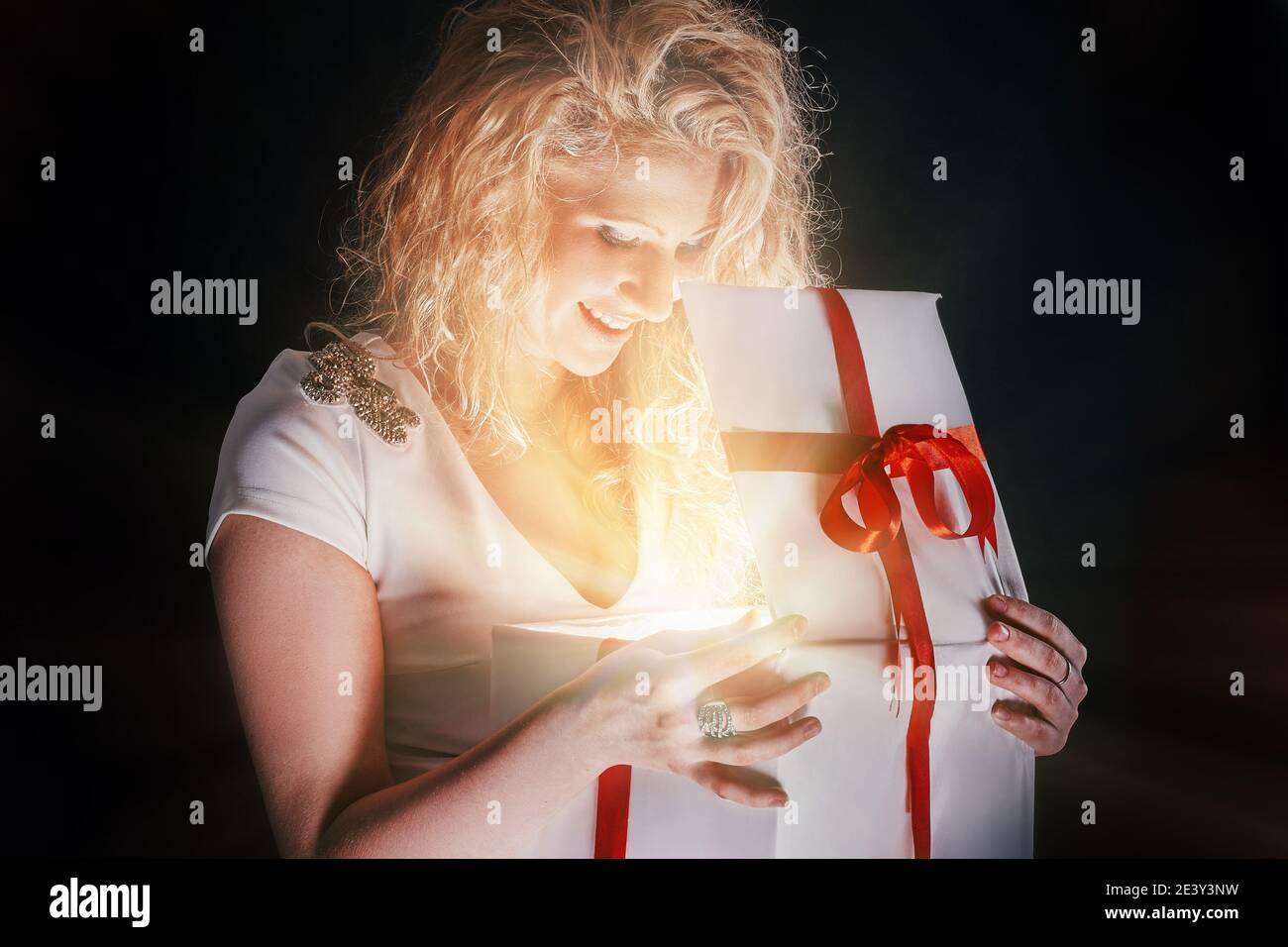 beautiful young woman opening gift box . isolated on black Stock Photo ...