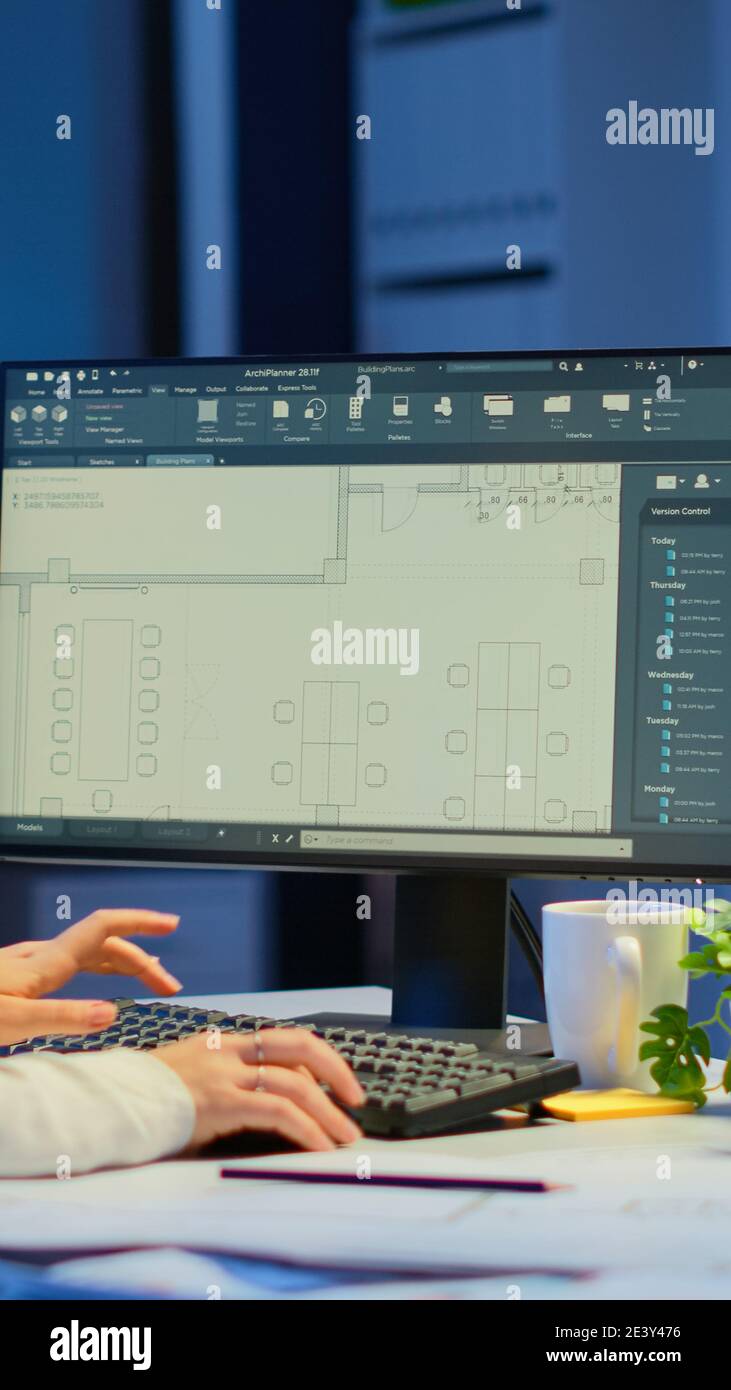 Woman architect matching digital plans from pc with blueprints working ...