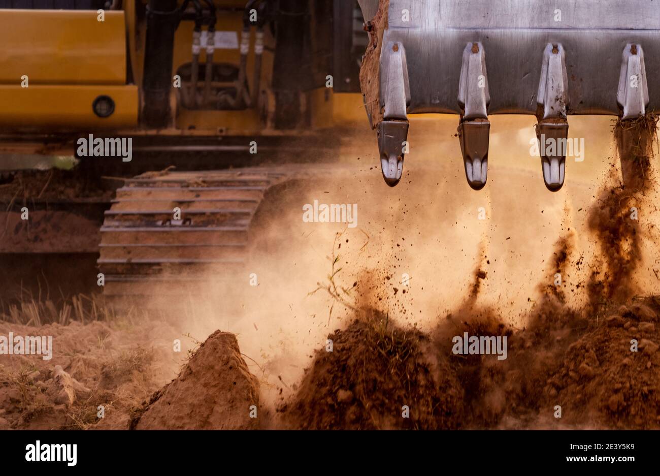 Selective focus on metal bucket teeth of backhoe digging soil. Backhoe ...