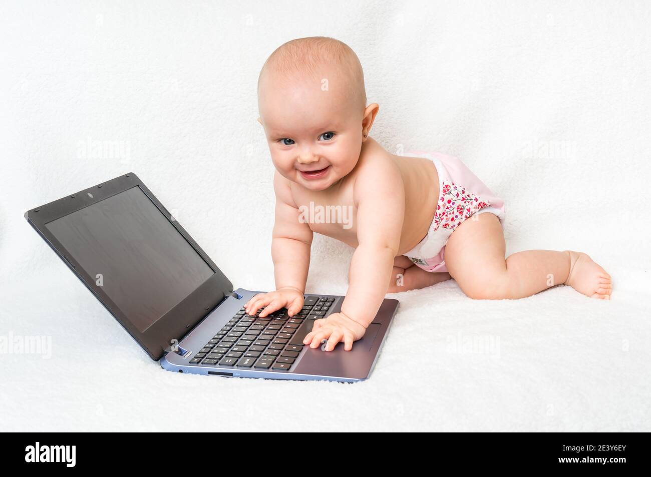 Cute baby with laptop computer on the white blanket background Stock ...