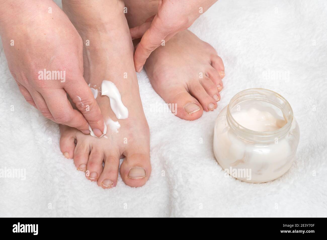 Woman applying moisturizer cream on her feet - skin care concept Stock ...