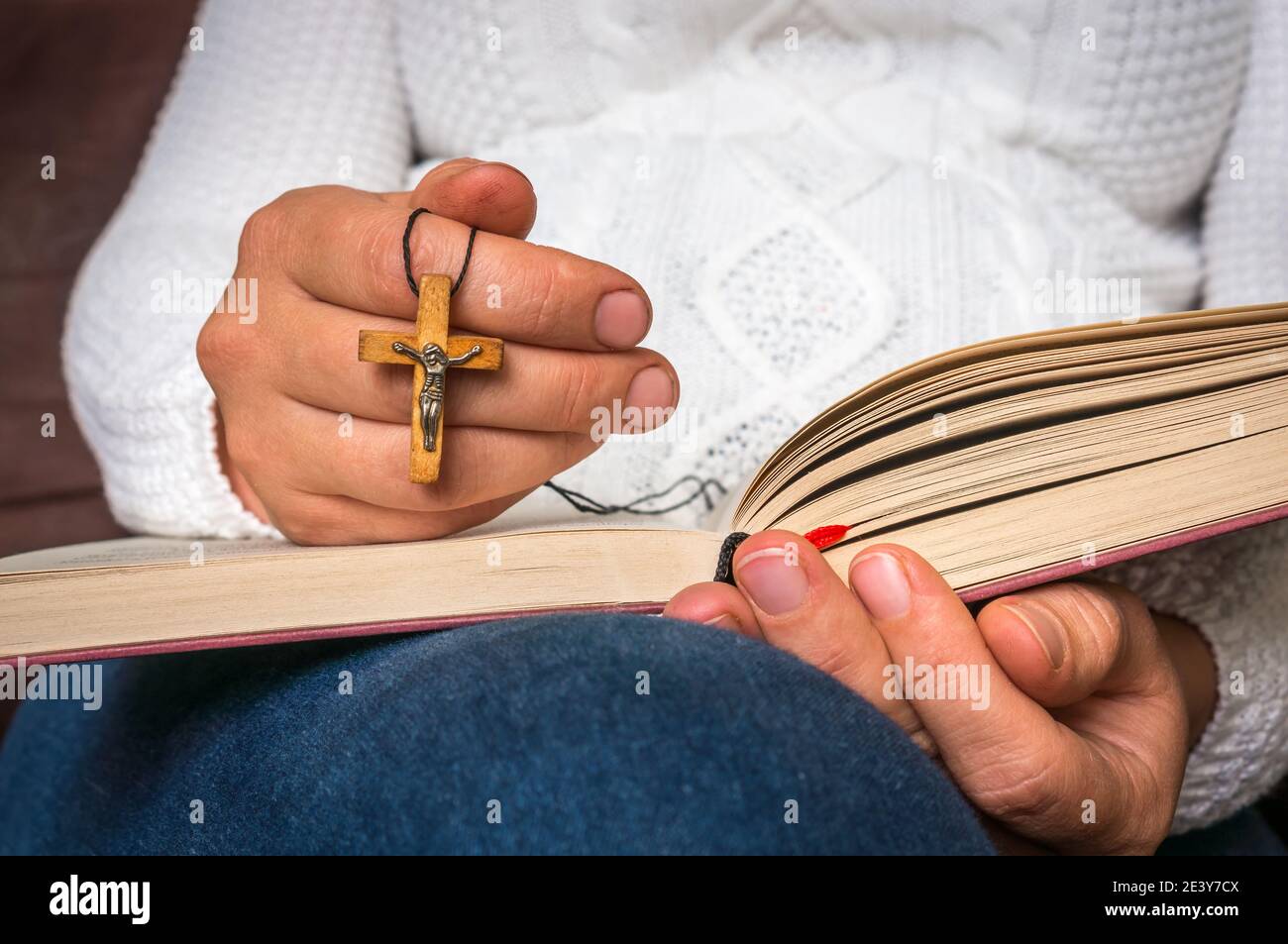 Christian woman with wooden cross reading a holy Bible - religious ...