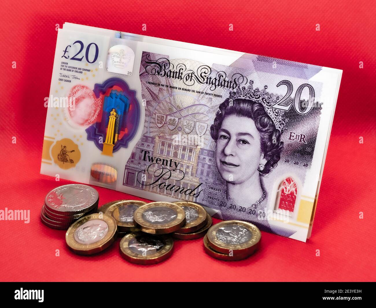 Closeup of new £20 twenty pound notes with sterling coins in front ...