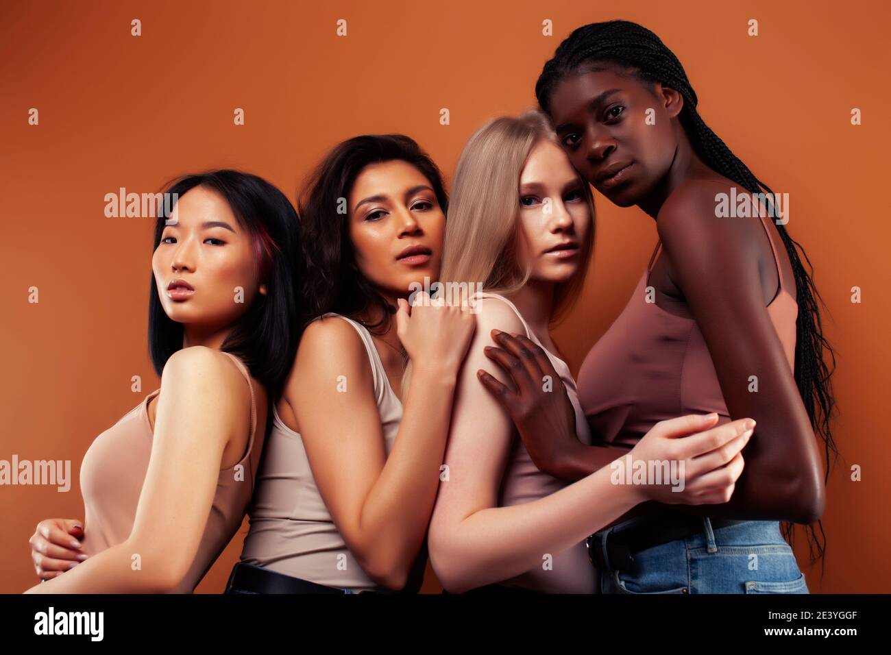 young pretty asian, caucasian, afro woman posing cheerful together on brown background ...