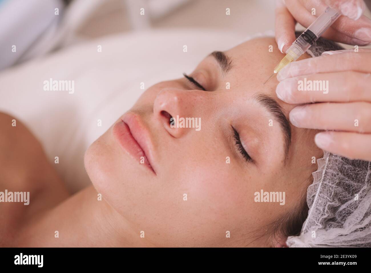 Close up of a beautiful young woman receiving face filler injections in ...