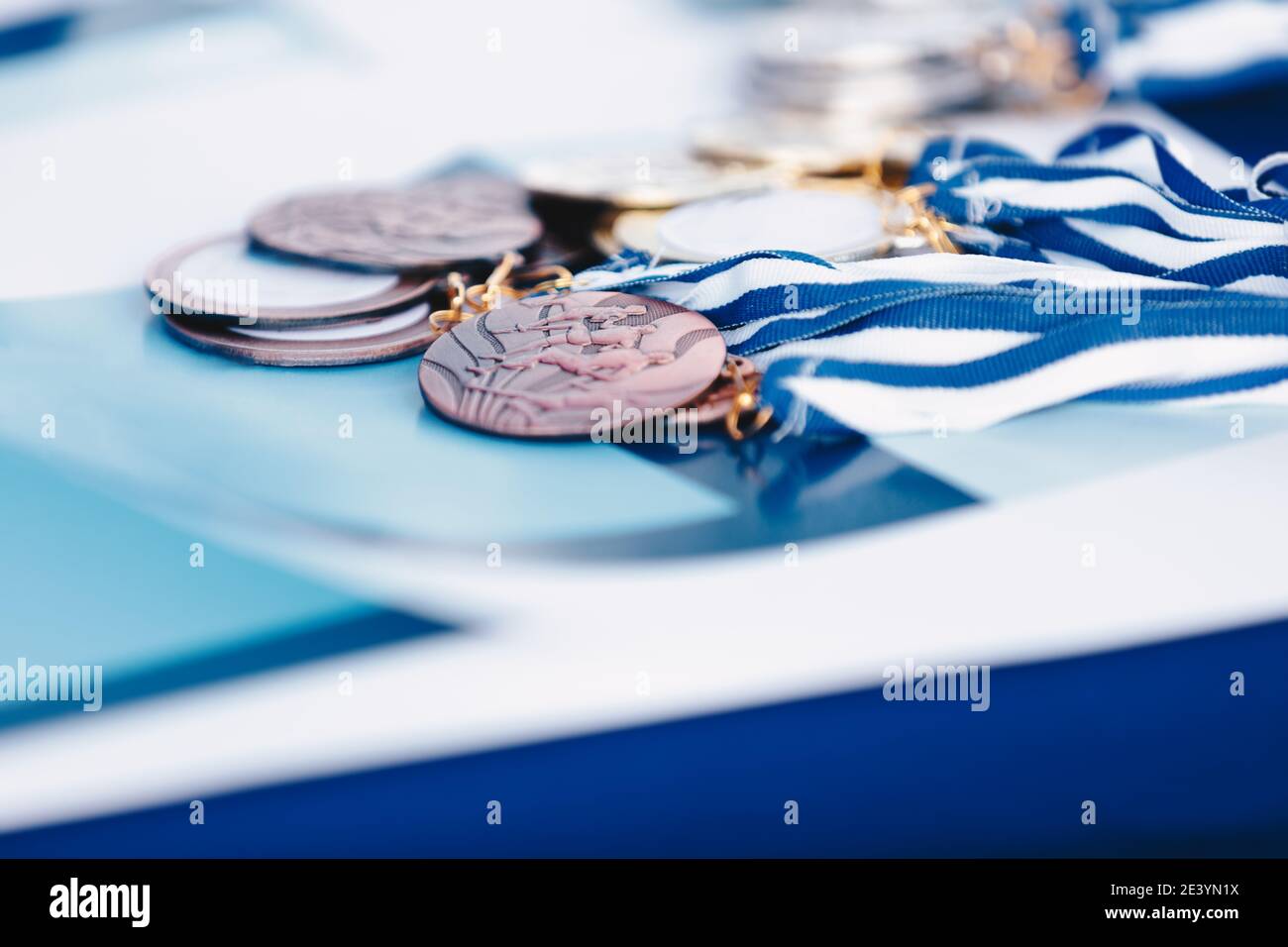 A bunch of marathon finisher's medals lying on certificate. Race ...