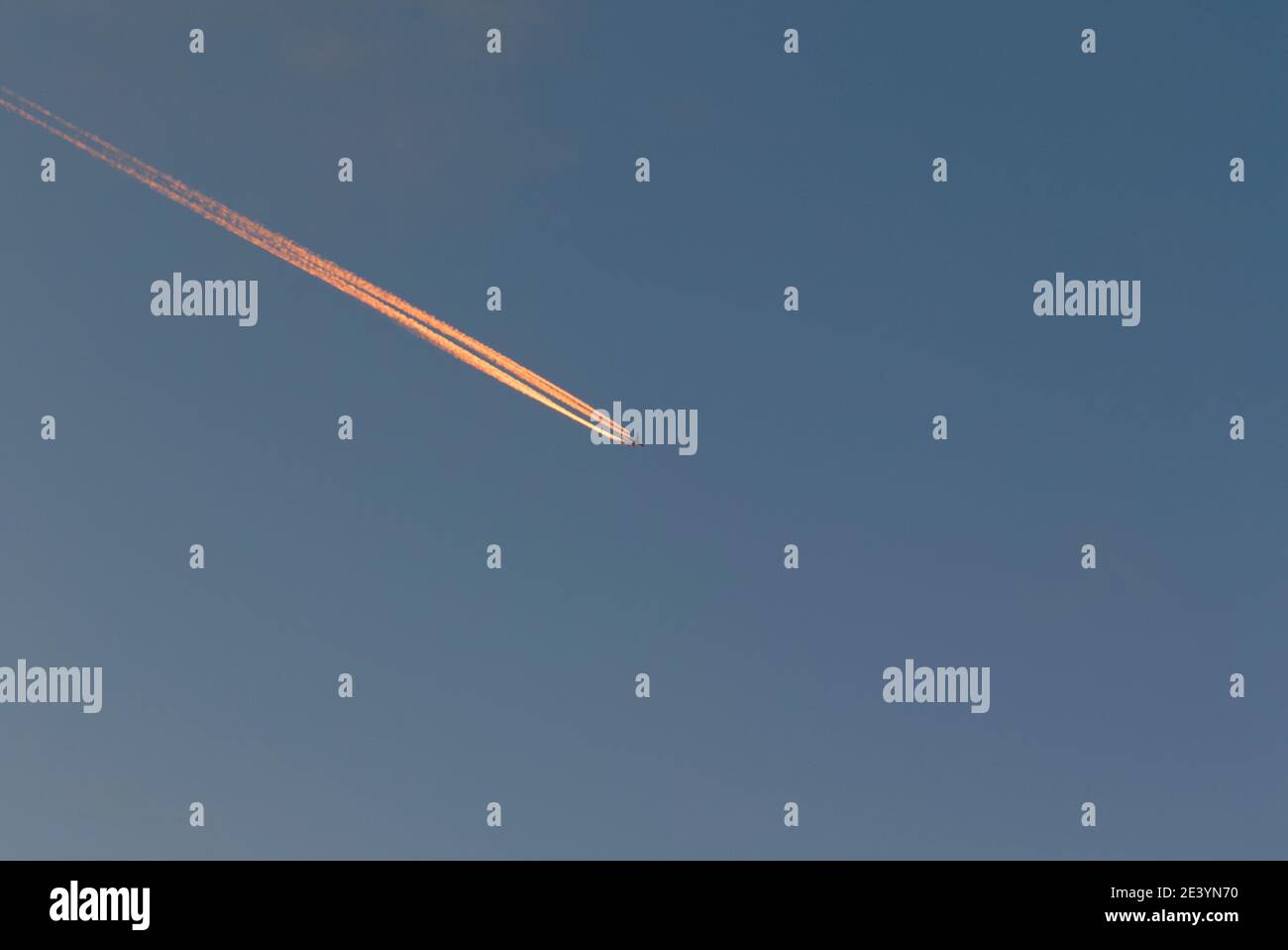 Aircraft contrails at sunset Stock Photo - Alamy