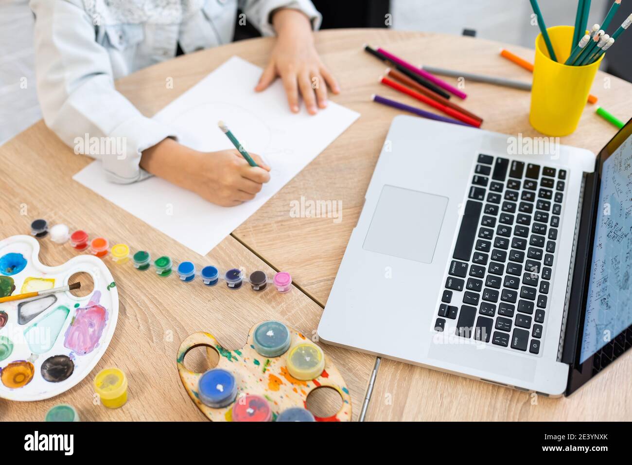Young girl spending a time drawing using online lessons on laptop ...