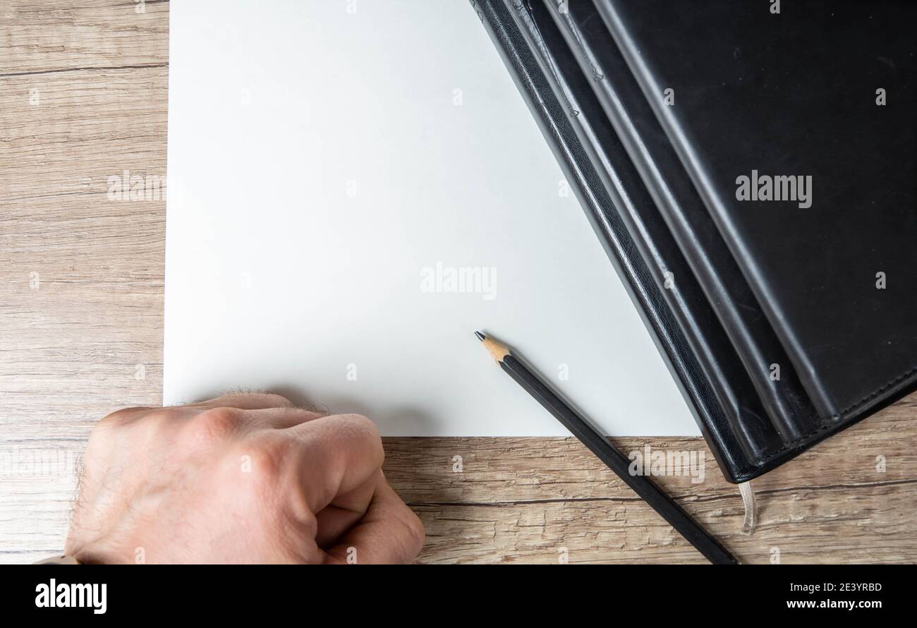 Stack of personal leather bounded journals. Black pencil on empty paper ...