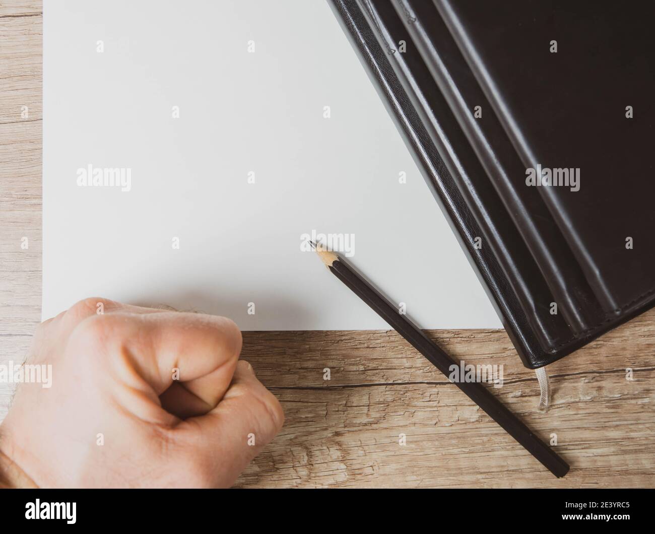 Stack of personal leather bounded journals. Black pencil on empty paper ...