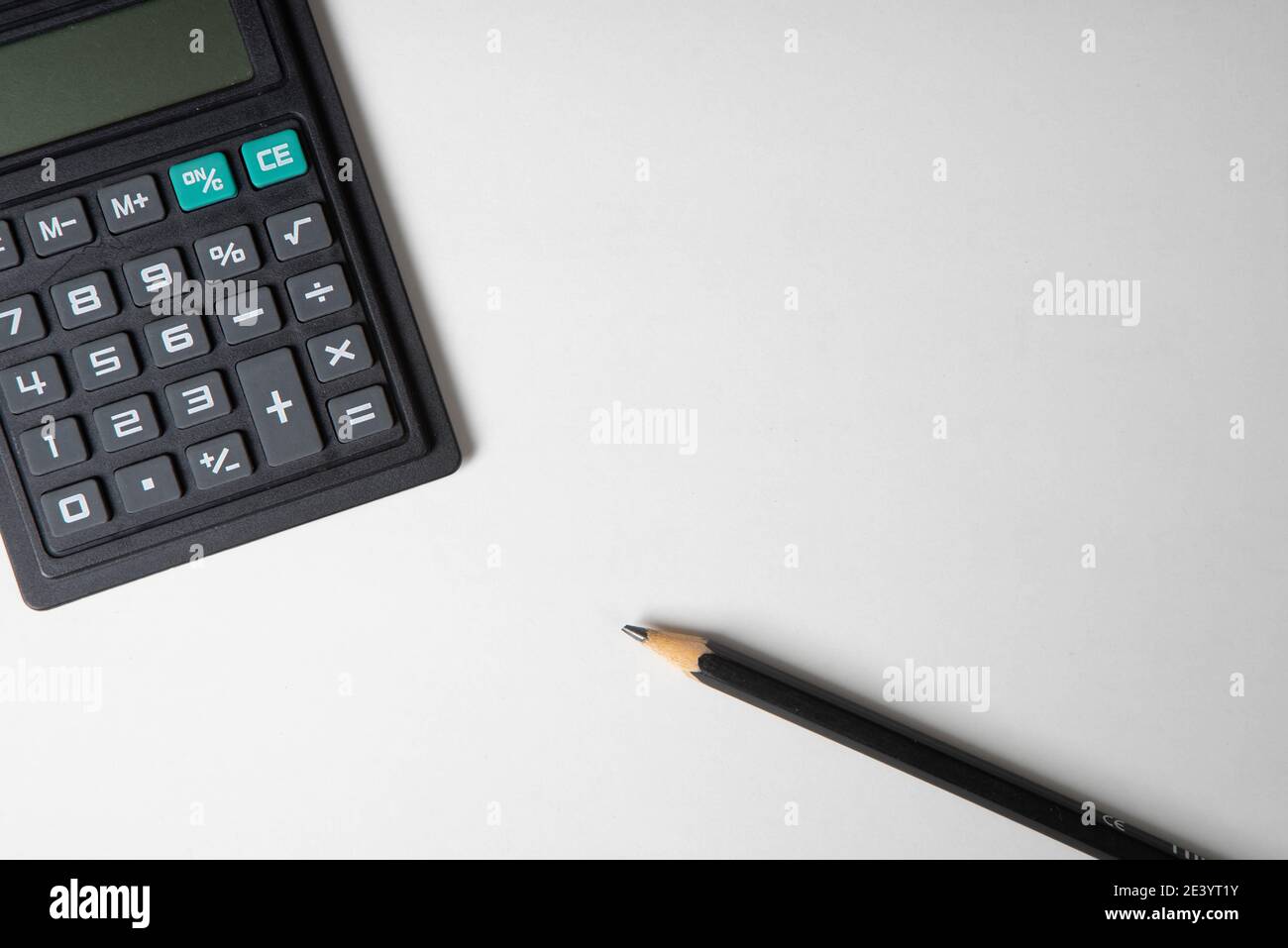 Close-up of black pencil and calculator on empty white paper blank. Top ...