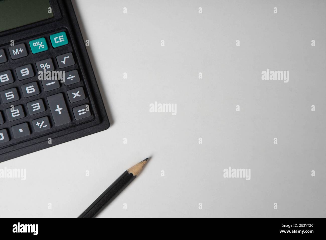 Close-up of black pencil and calculator on empty white paper blank. Top ...