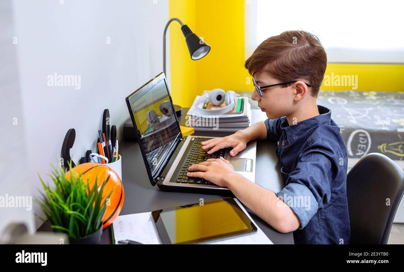 Boy doing homework with laptop Stock Photo - Alamy