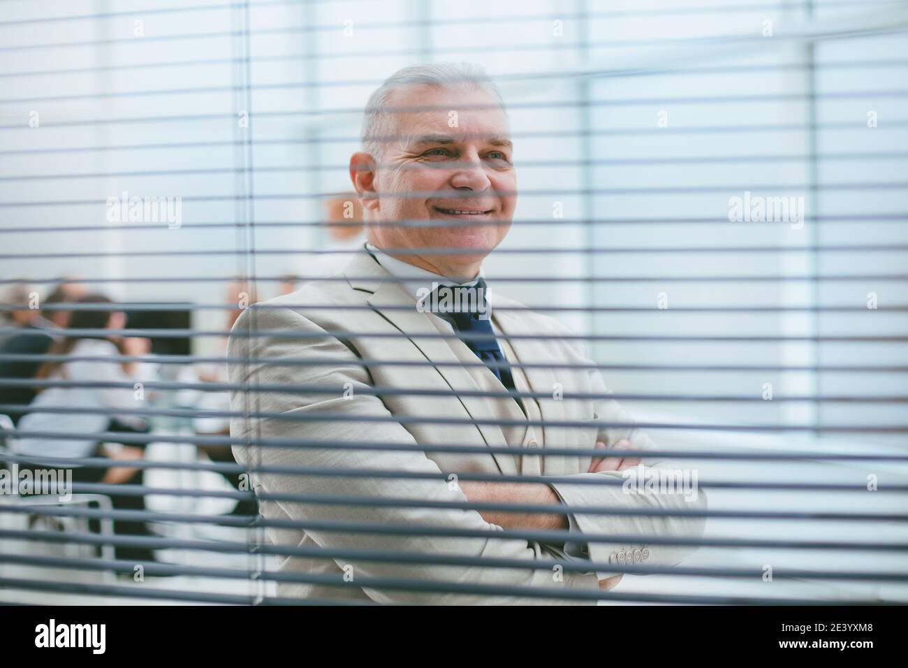 close up. cheerful office employee looking through window blinds Stock ...