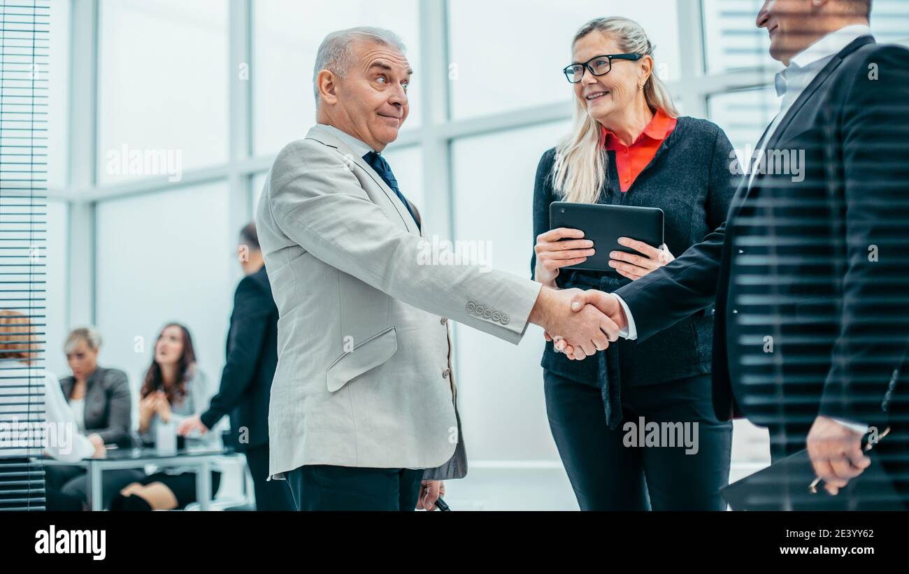 smiling business partners shaking hands with each other Stock Photo - Alamy