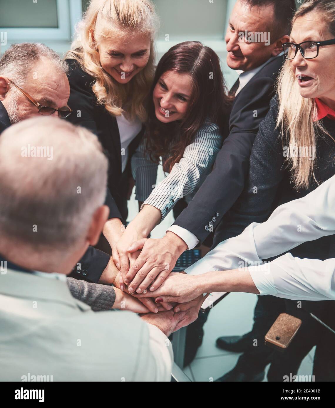 close up. happy group of employees making a stack of hands Stock Photo ...
