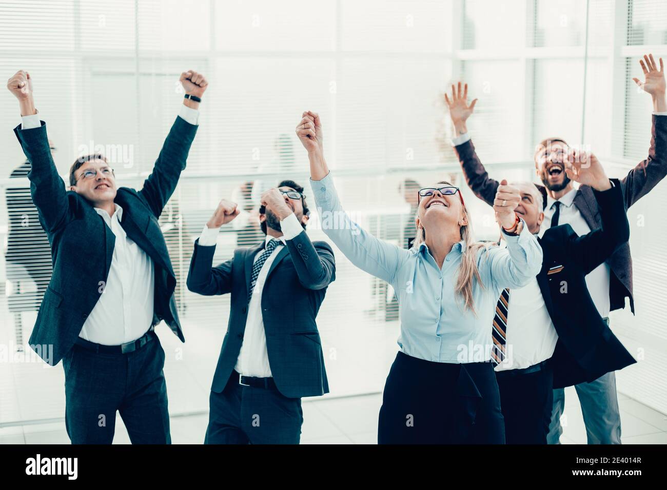 happy business woman standing in front of a cheering business team ...