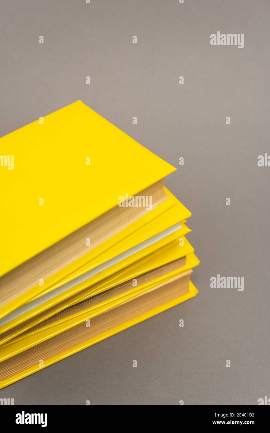 pile of yellow notebooks isolated on grey Stock Photo - Alamy
