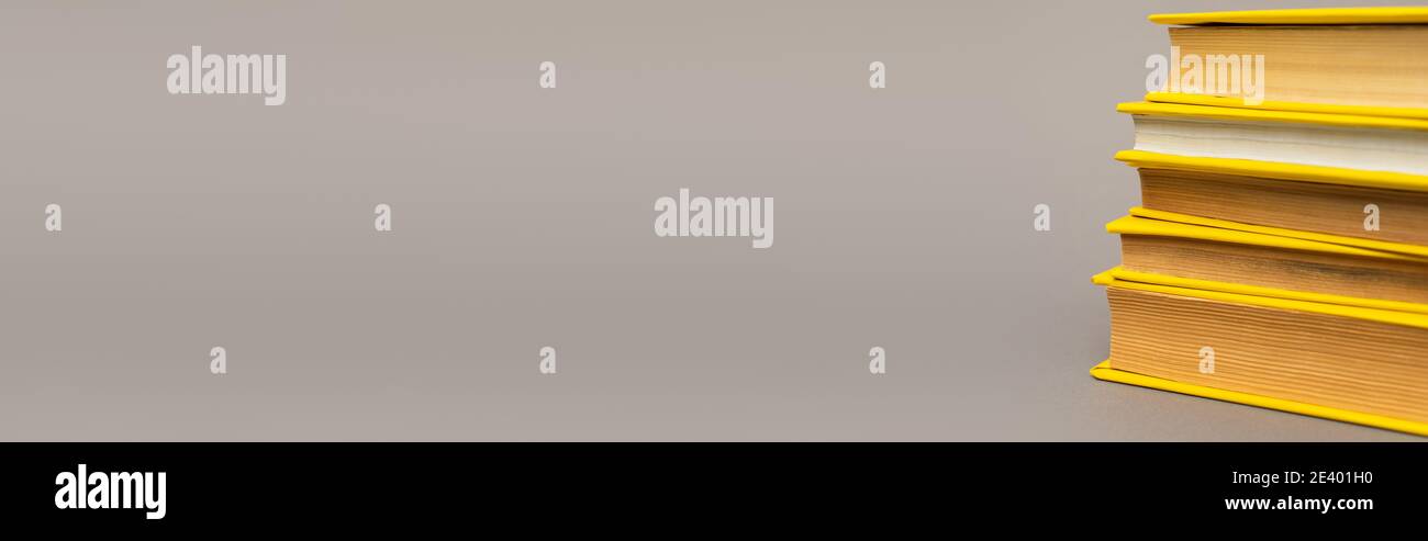 stack of yellow notebooks isolated on grey, banner Stock Photo - Alamy