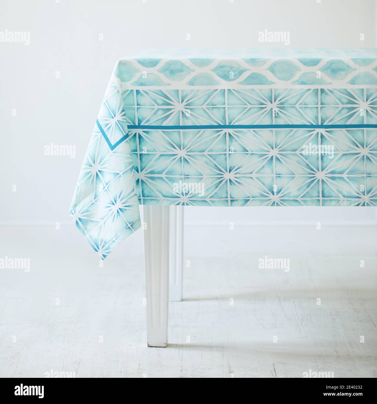 Decorative tablecloth with blue patterns on a table on a white ...